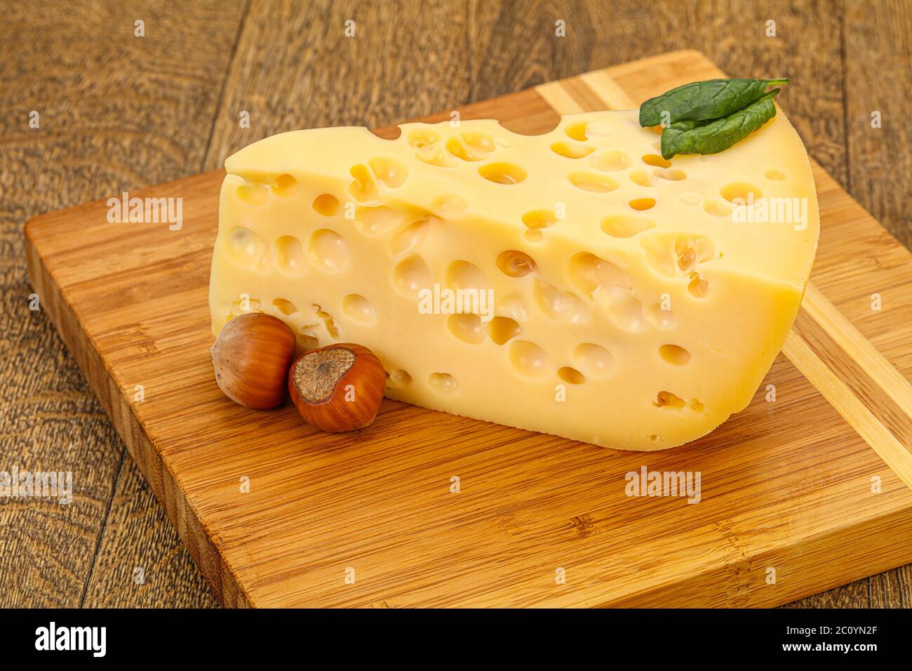 Maasdam cheese - dairy yellow triangle with holes Stock Photo - Alamy