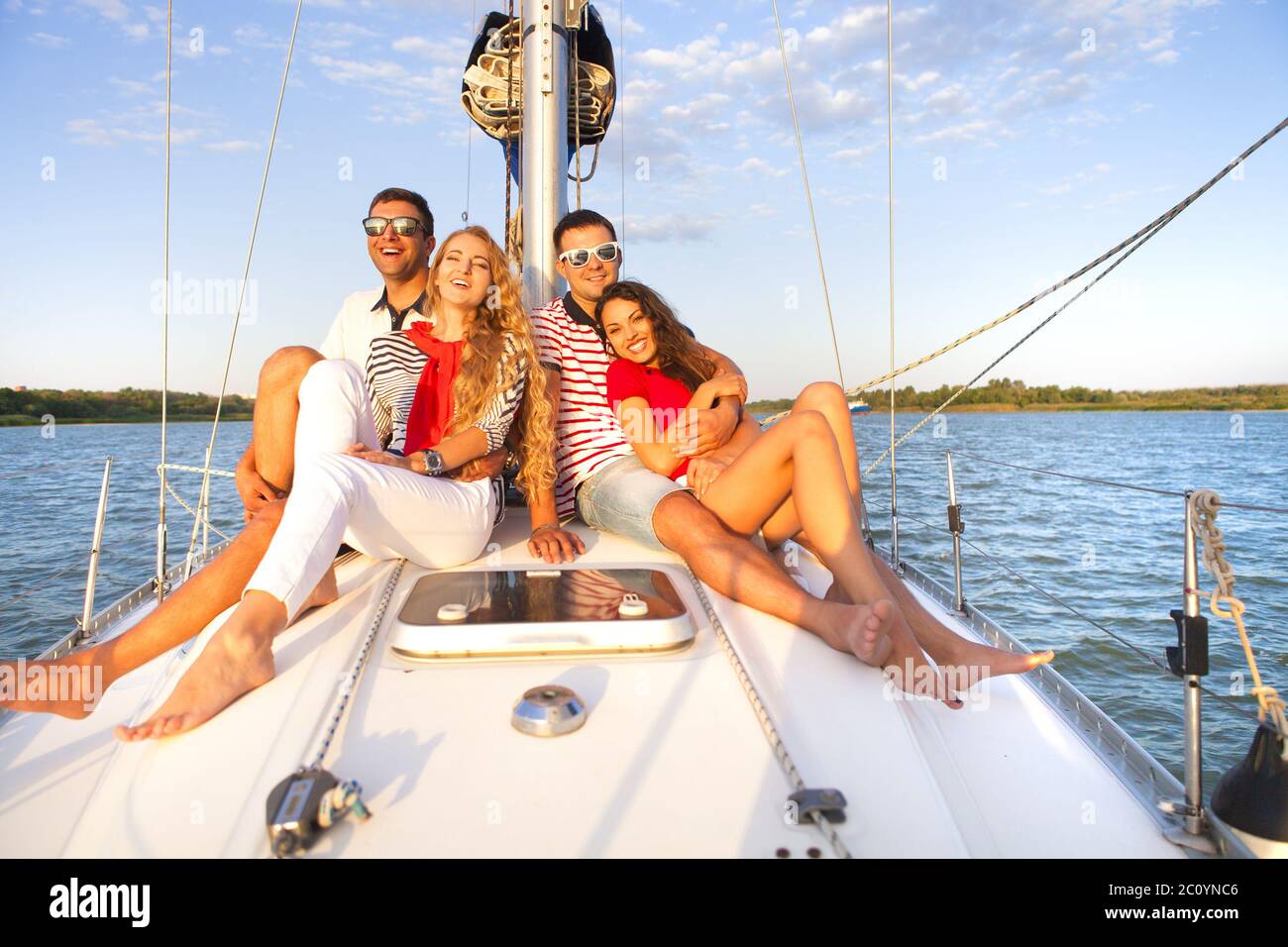Smiling friends on yacht deck and greeting Stock Photo - Alamy