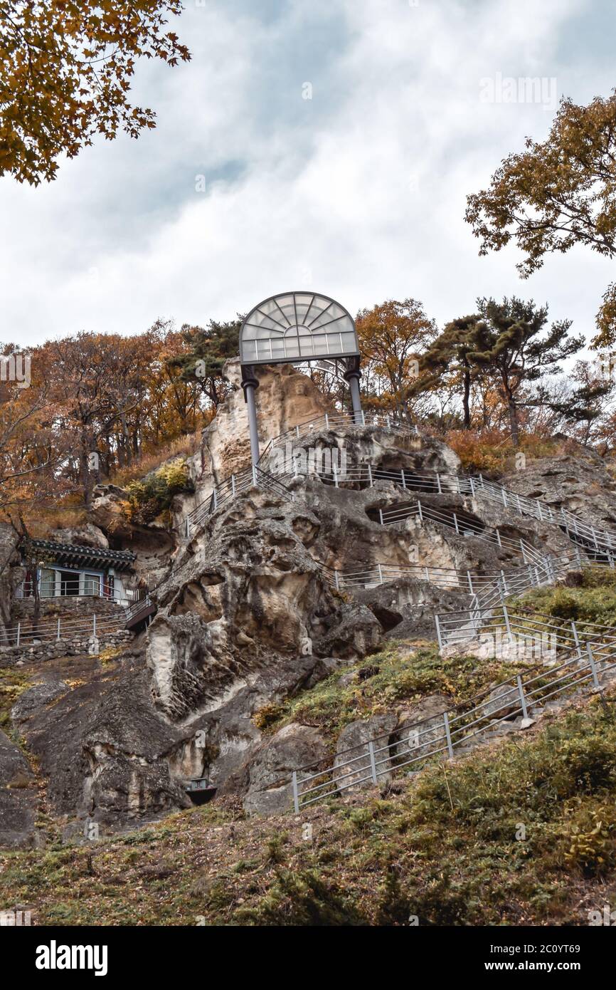 View of the mountain path leading to sitting Buddha carved in a rock in ...