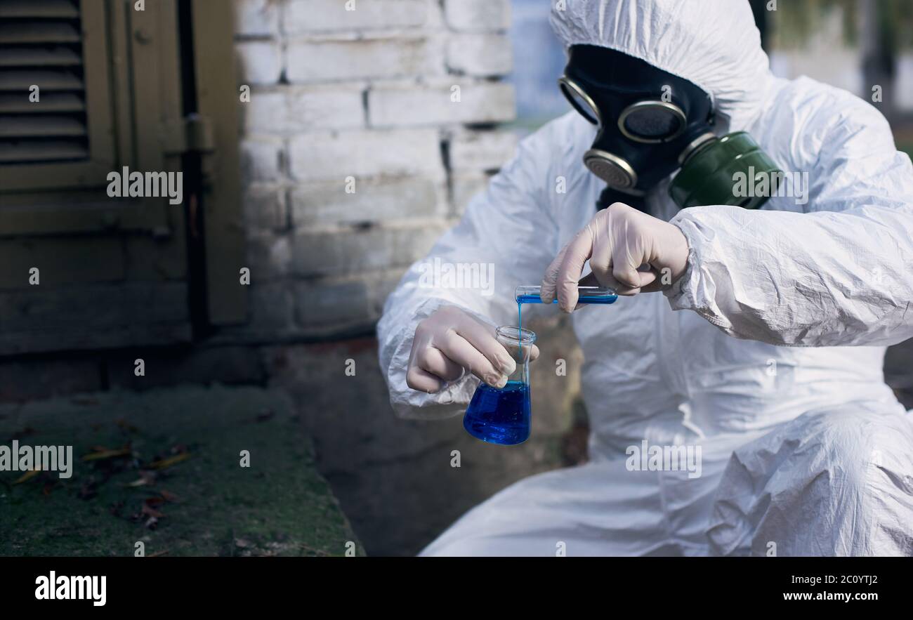 Ecologist in protective suit, gas mask and gloves. Scientist making ...