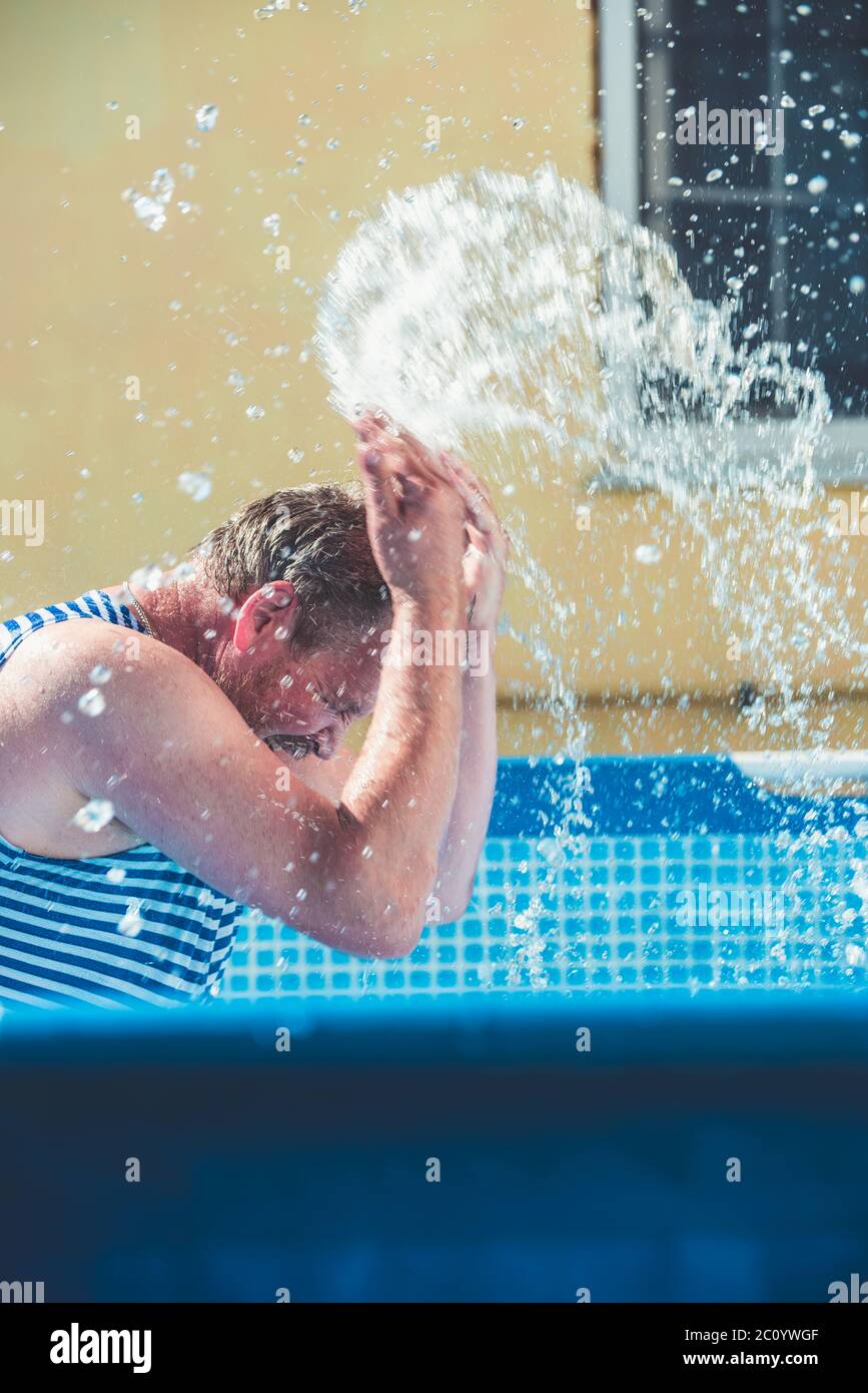 The man with the water splashing in the pool, toning Stock Photo - Alamy