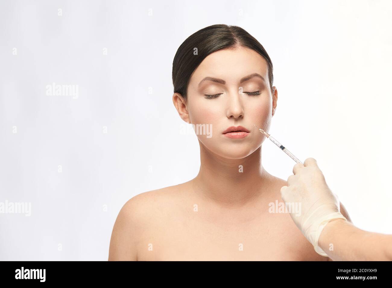 Face needle injection. Young woman cosmetology procedure. Doctor gloves ...