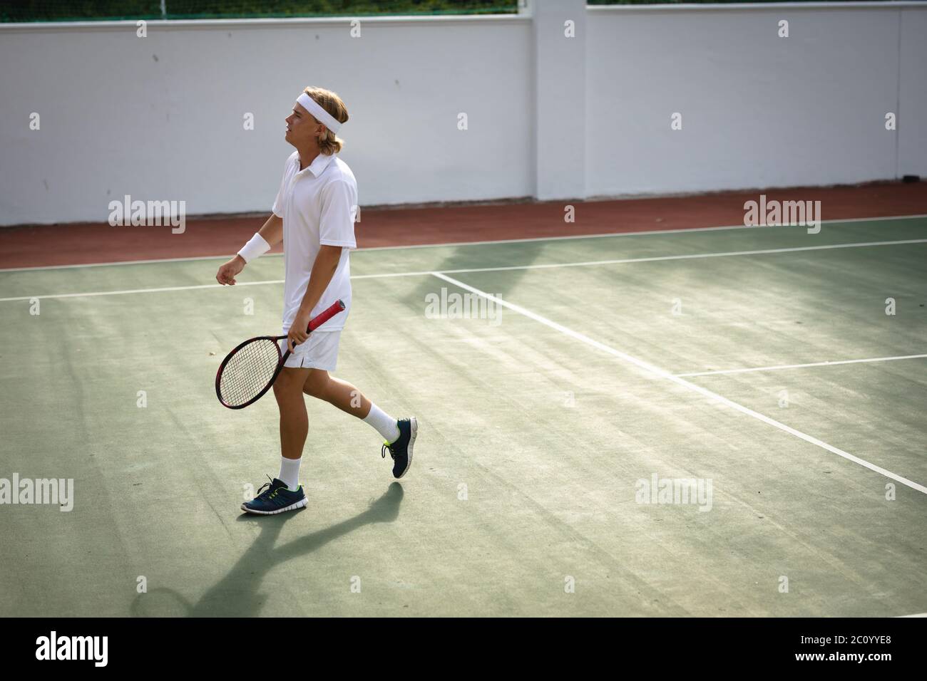 Caucasian man training on a tennis court Stock Photo - Alamy