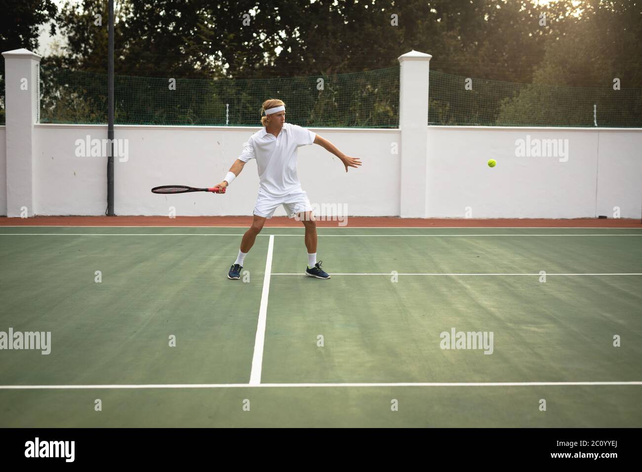 Caucasian man training on a tennis court Stock Photo - Alamy