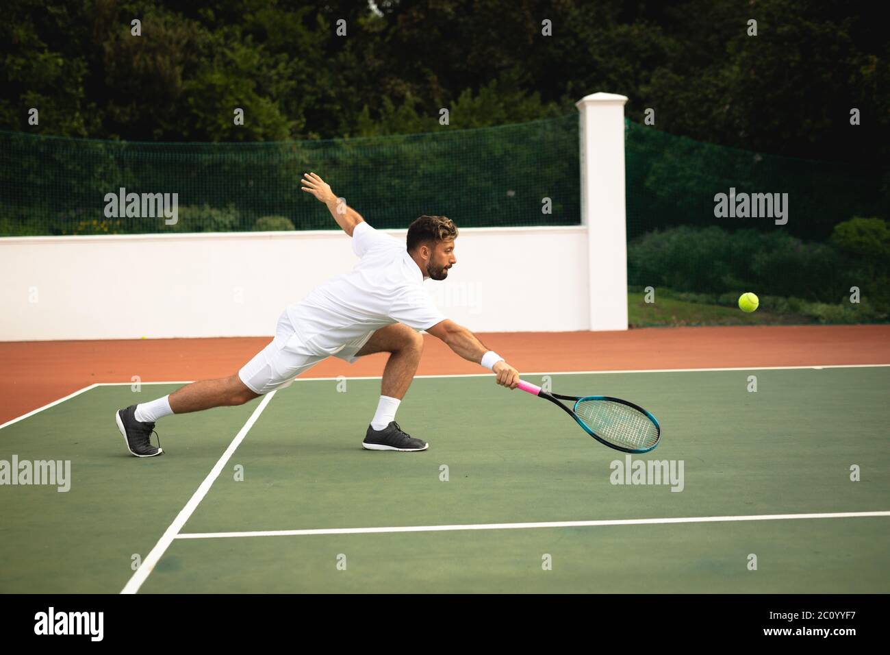 Caucasian man training on a tennis court Stock Photo - Alamy