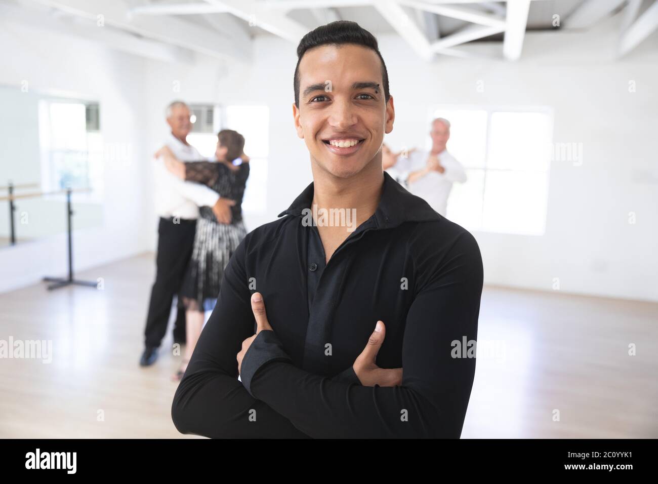 Portrait of mixed race dance teacher during ballroom dancing class ...
