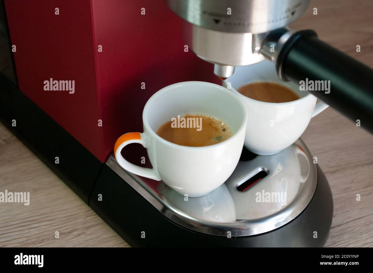 Two small cups with espresso coffee. Morning drink. Red coffee machine ...