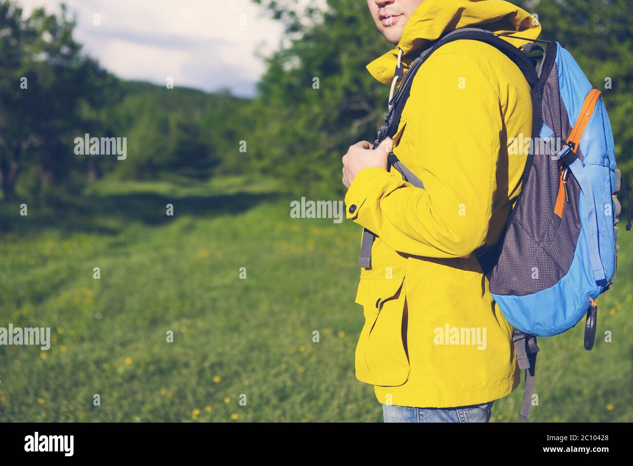 Side view of young man with backpack hiking Stock Photo - Alamy