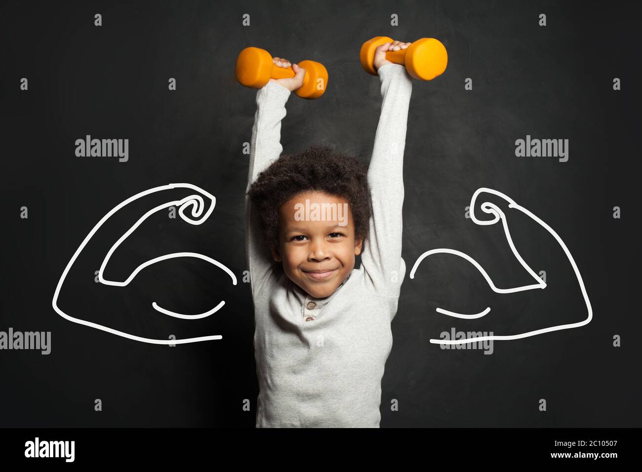 Strong black child boy with dumbbells Stock Photo - Alamy