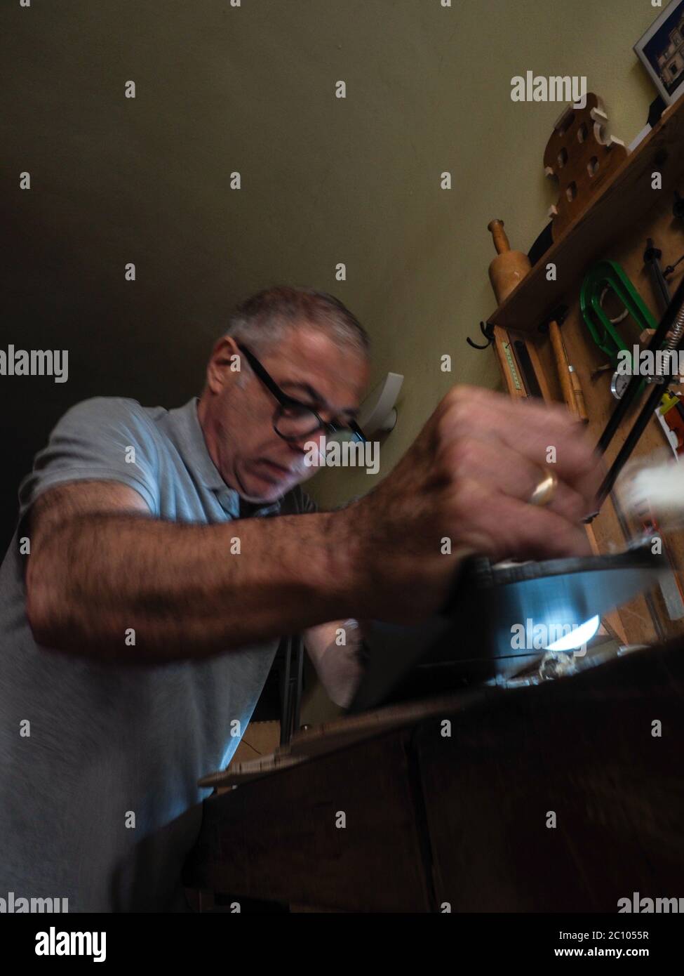 Professional luthier violinmaker artisan working on making a handmade ...
