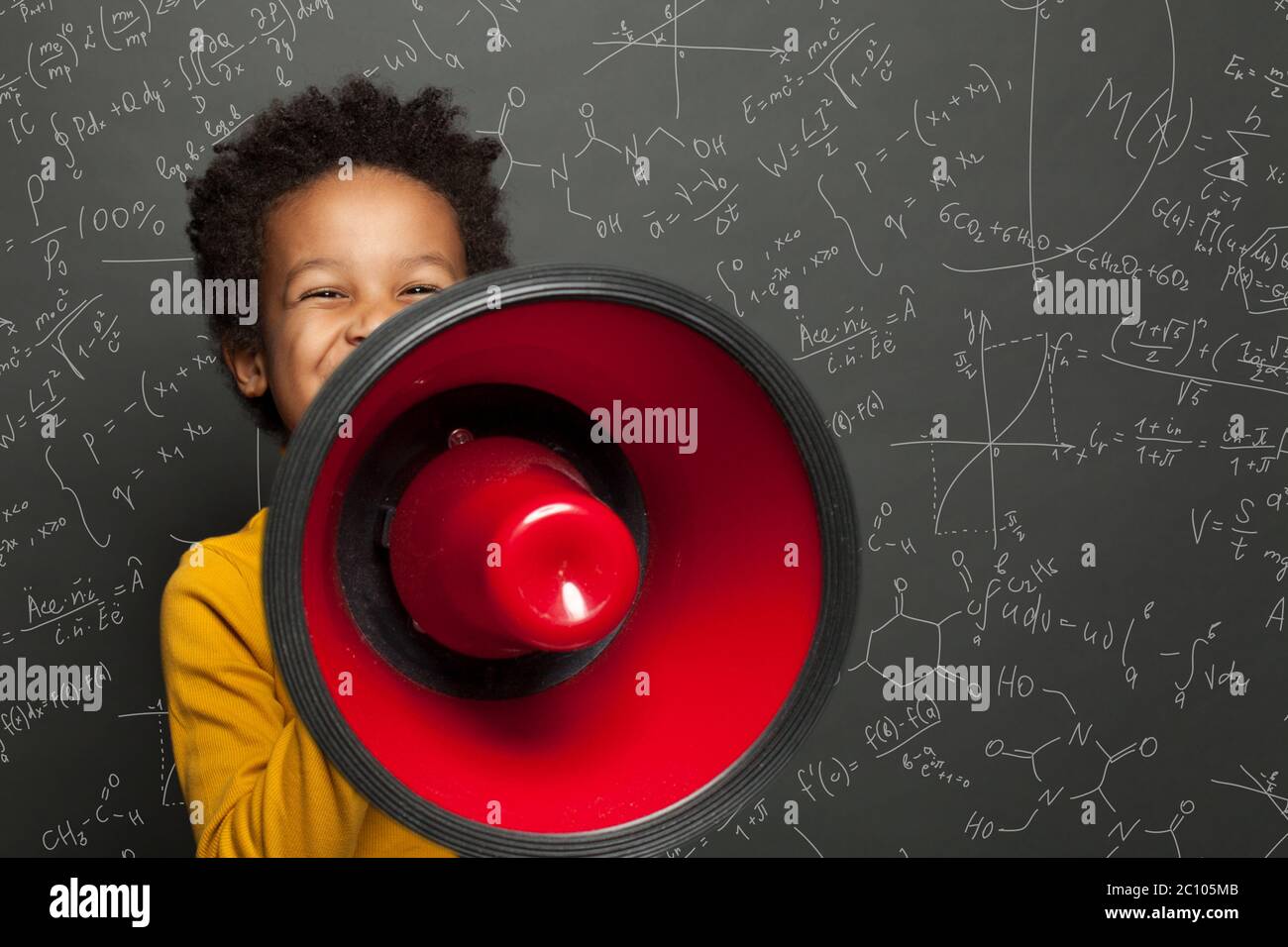 Smart black child with megaphone loudspeaker on chalkboard background ...