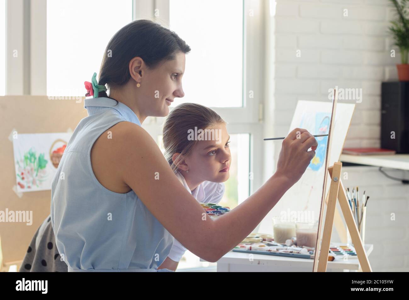 Drawing teacher shows girl how to draw Stock Photo - Alamy