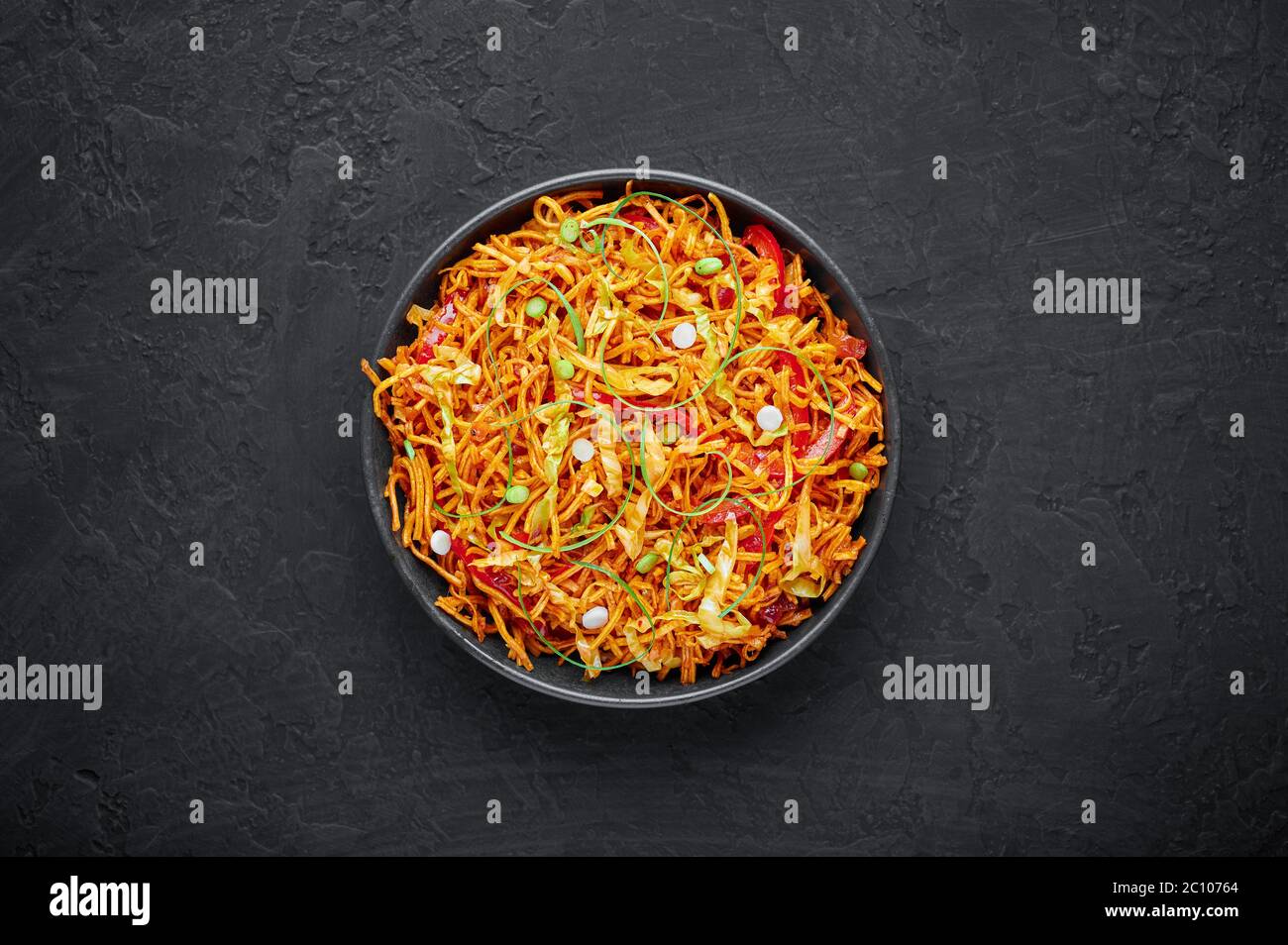 Chinese Bhel in black bowl on dark slate table top. Chinese Bhel is ...