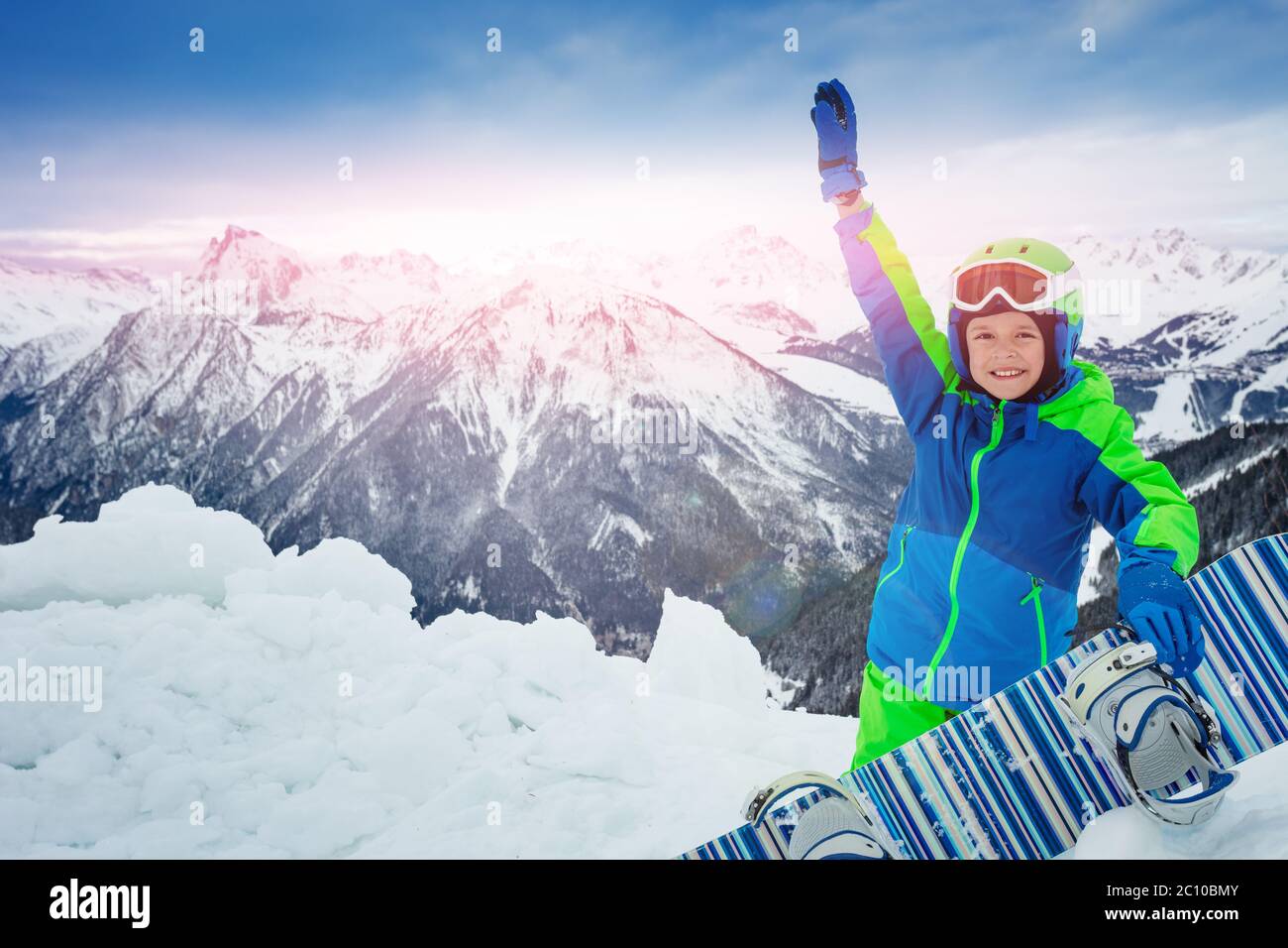 Close portrait of a boy lay with snowboard in snow lift hand show big ...