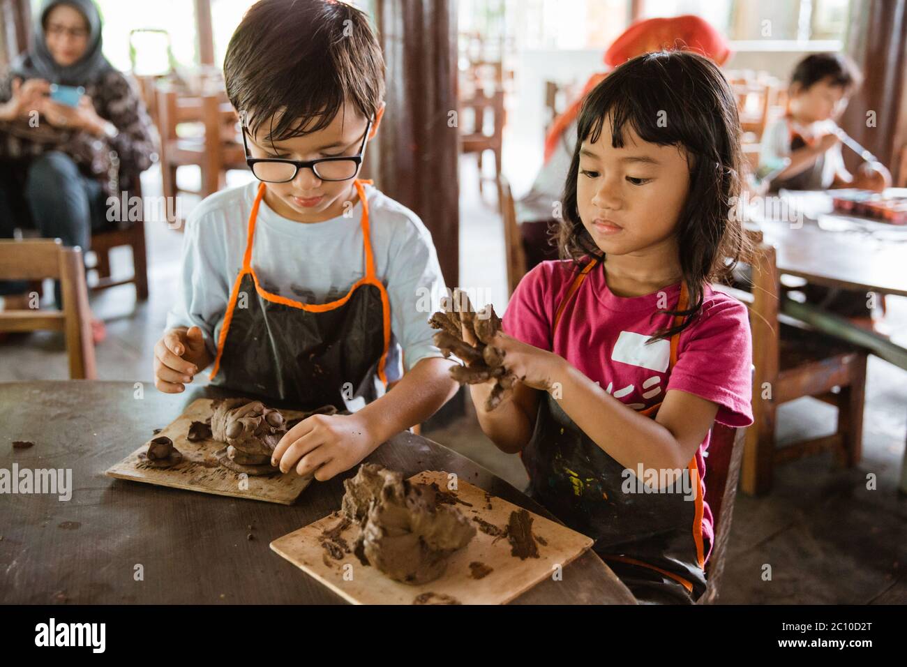 children are busy playing clay handicrafts in the pottery workshop ...