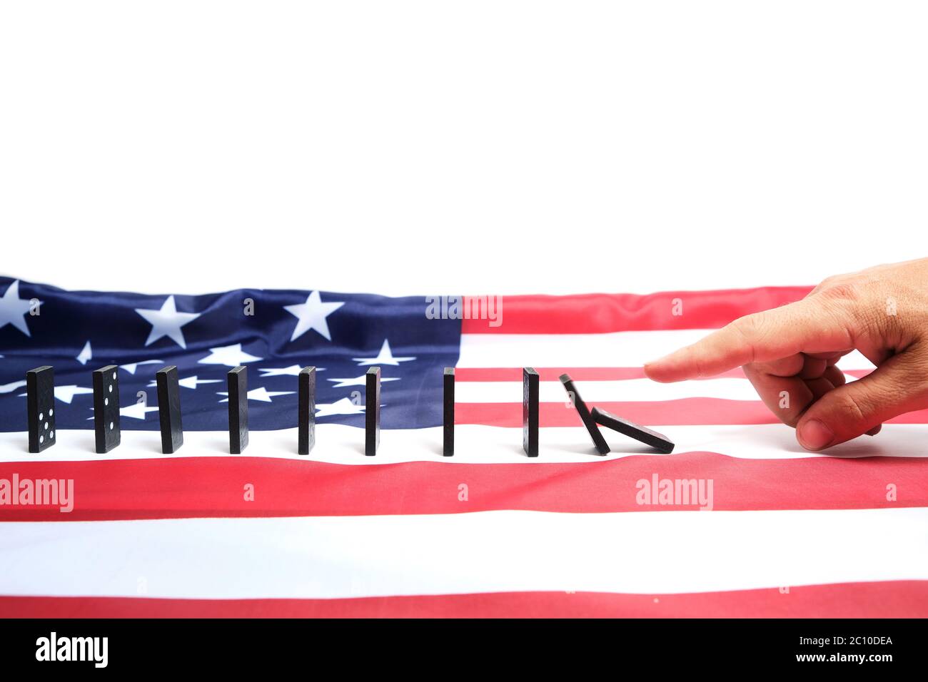 White man's finger pushing a Domino causing a chain reaction against ...