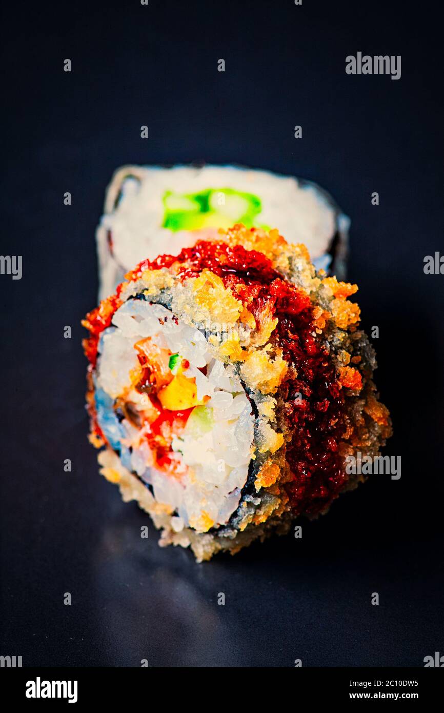 Two sushi roll shot of black background with reflection, vertical image ...