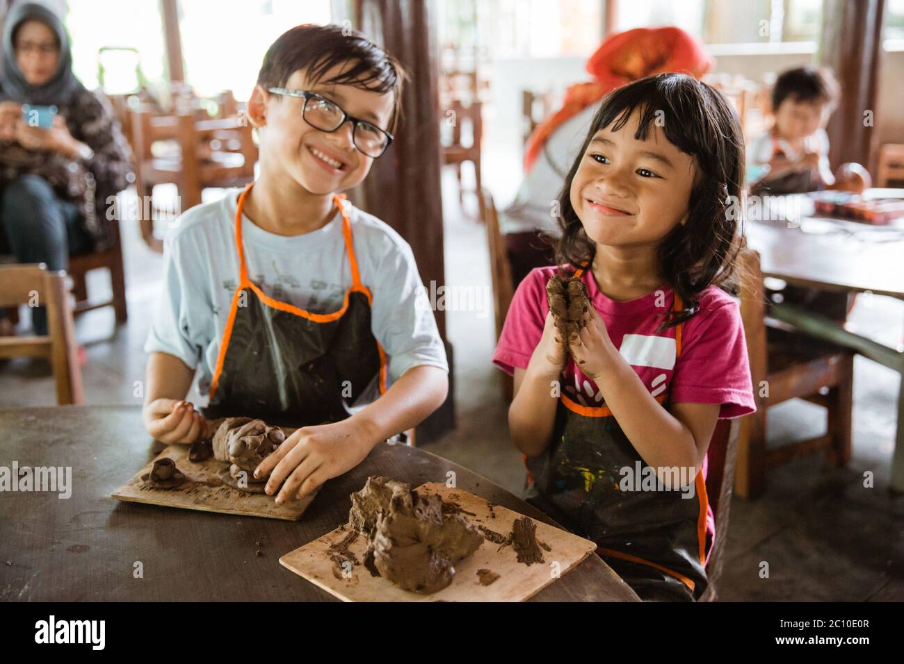 children are busy playing clay handicrafts in the pottery workshop ...