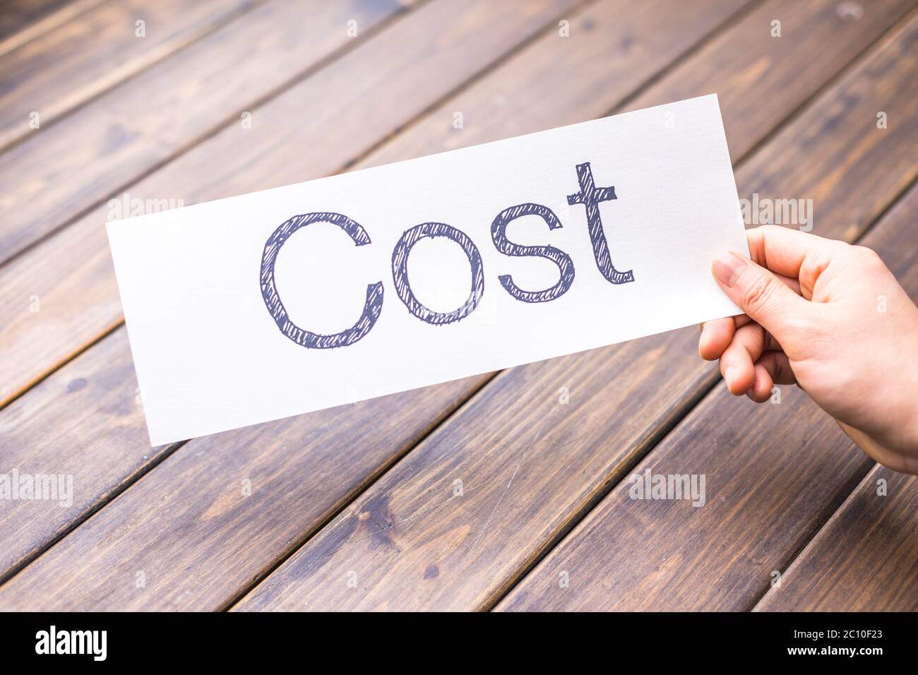 hand hold white paper with word cost Stock Photo - Alamy