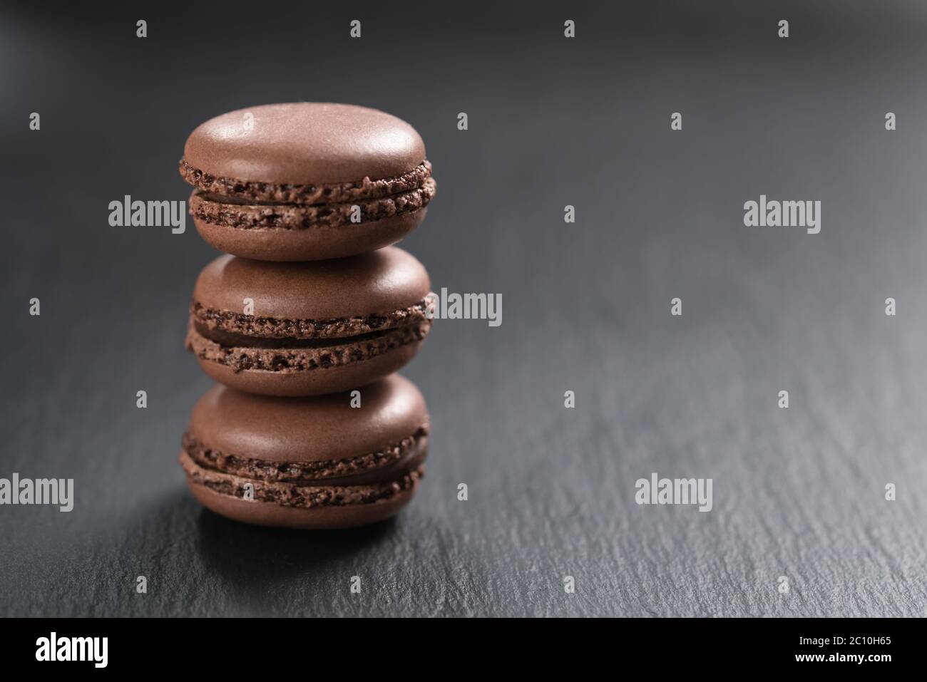 Chocolate macarons stacked on slate board with copy space Stock Photo ...