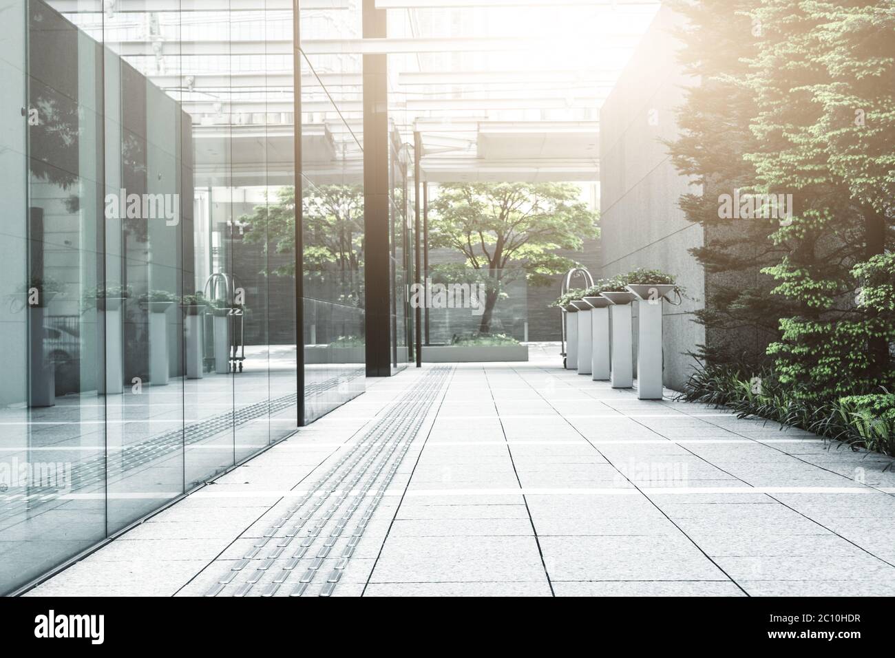 empty footpath through modern office buildings in tokyo with sunbeam ...