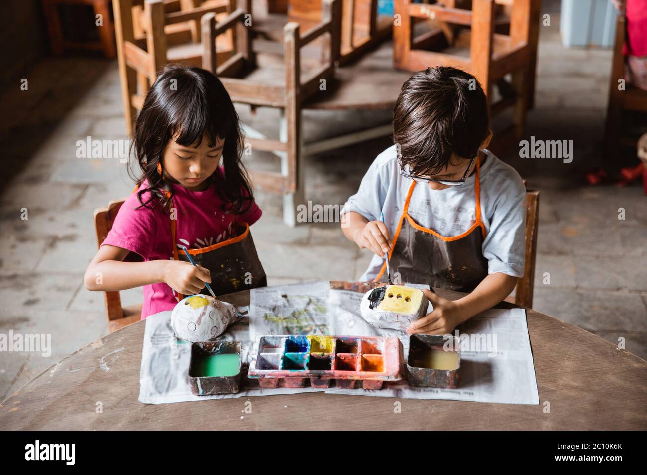 brother and sister painting crafts with colors in the pottery gallery ...