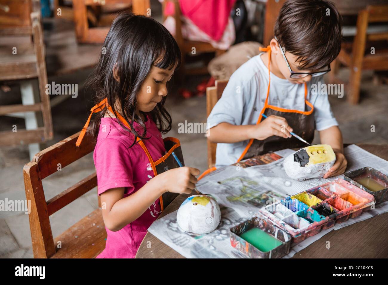 brother and sister painting crafts with colors in the pottery gallery ...