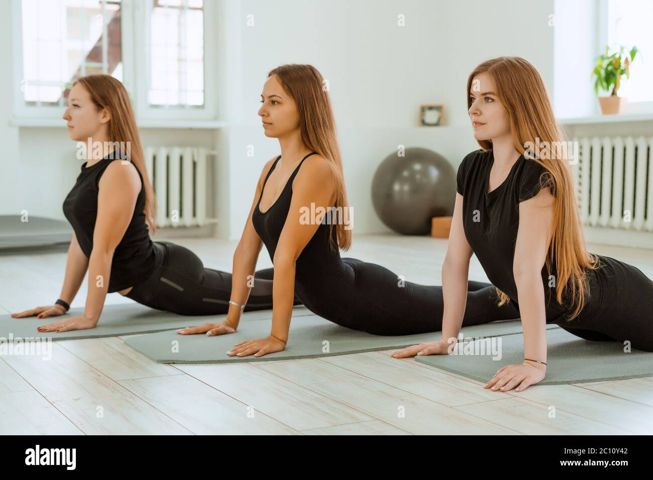 Stretching workout. A group of young girls in black uniforms are doing ...
