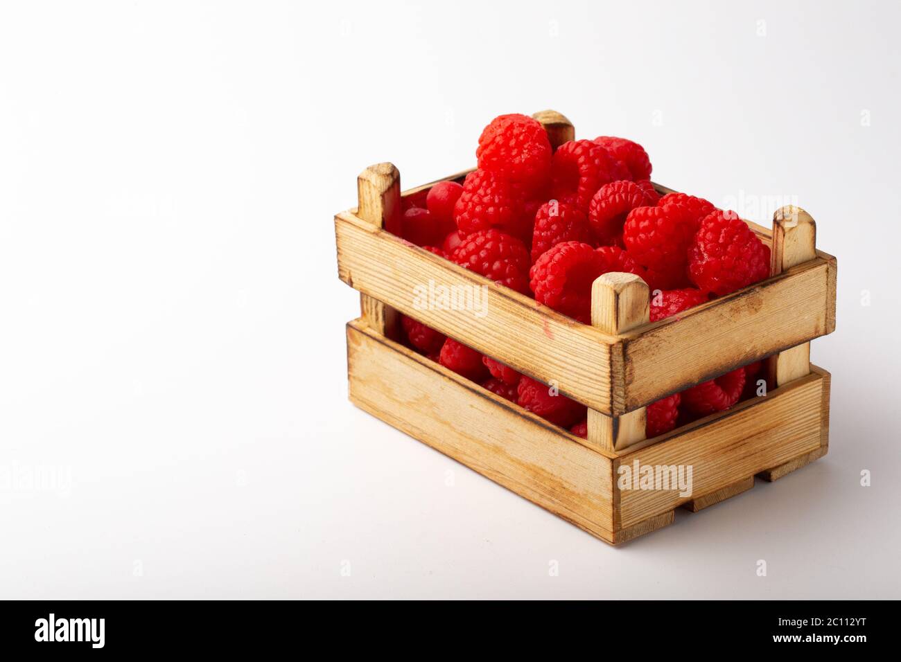 Some raspberries in a small wooden box on a white background Stock ...