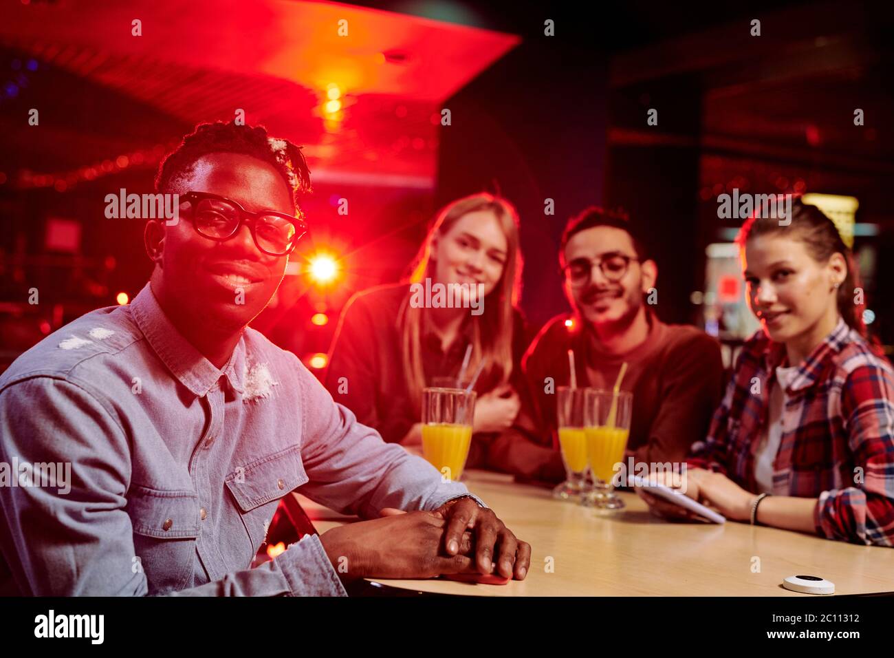Happy young man of African ethnicity in casualwear looking at you while ...