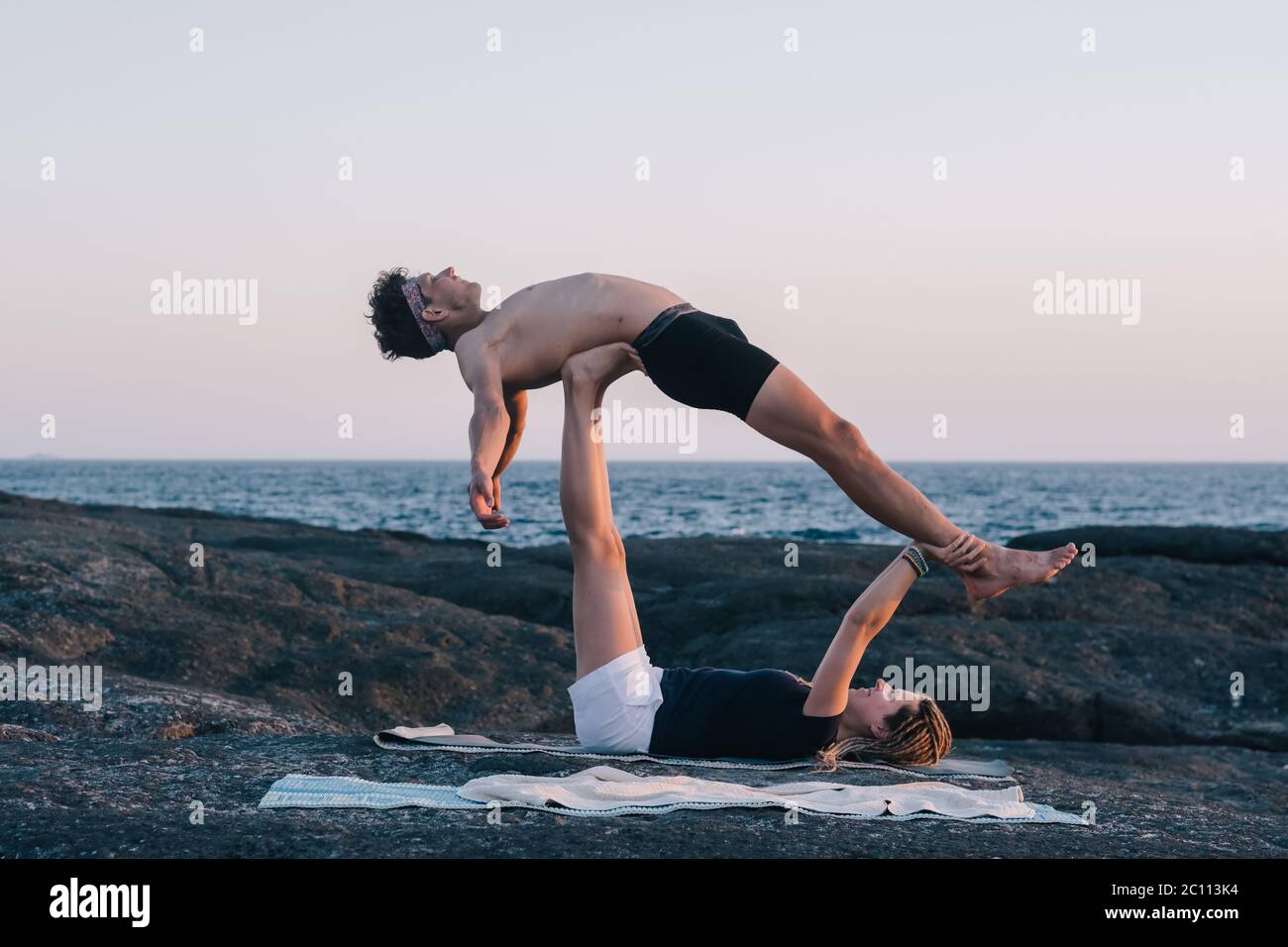 couple doing yoga exercises outdoors at the beach Stock Photo - Alamy