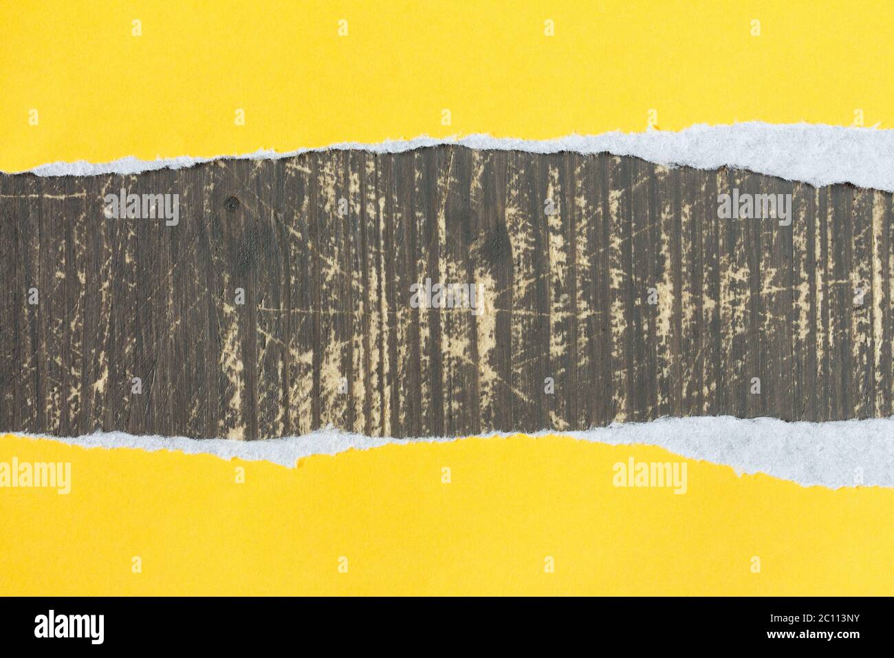Torn yellow paper with a wooden background Stock Photo - Alamy