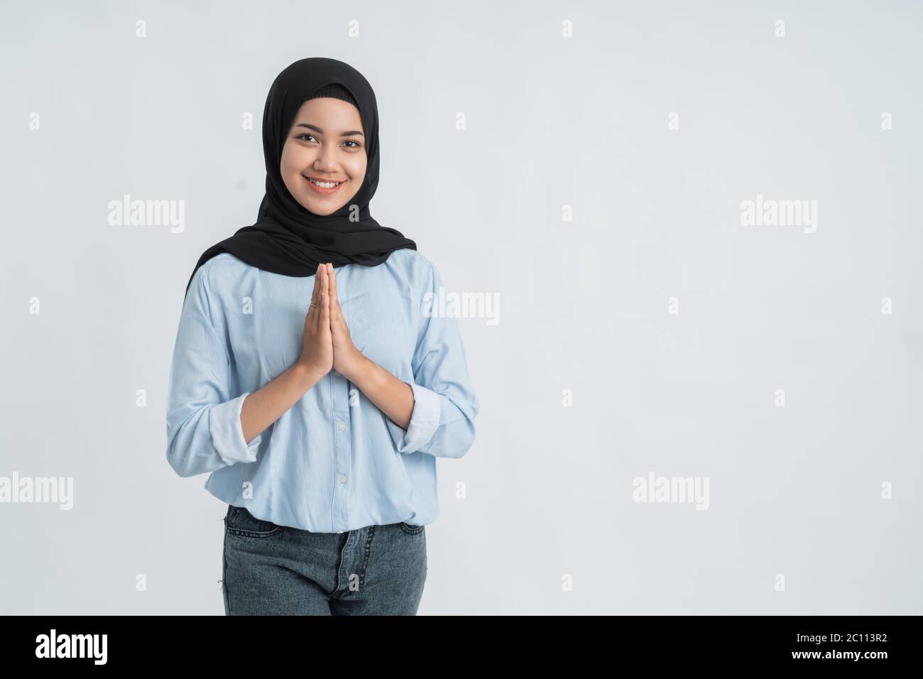 muslim woman smiling with hand showing greeting gesture Stock Photo - Alamy