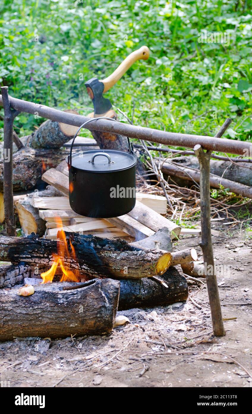 Tourist pot of water hanging over a fire of wood in the Camping Stock ...