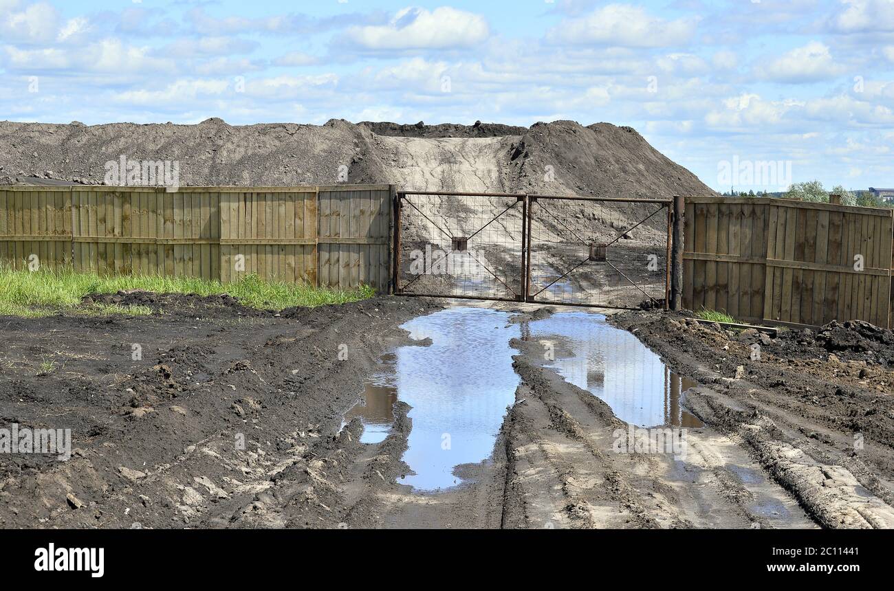 Dirt road, a pool and a lot of stored in the open air ground for a ...