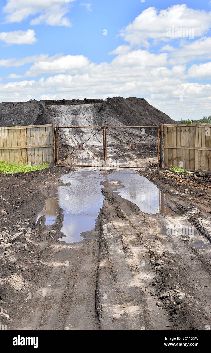 Dirt road, a pool and a lot of stored in the open air ground for a ...