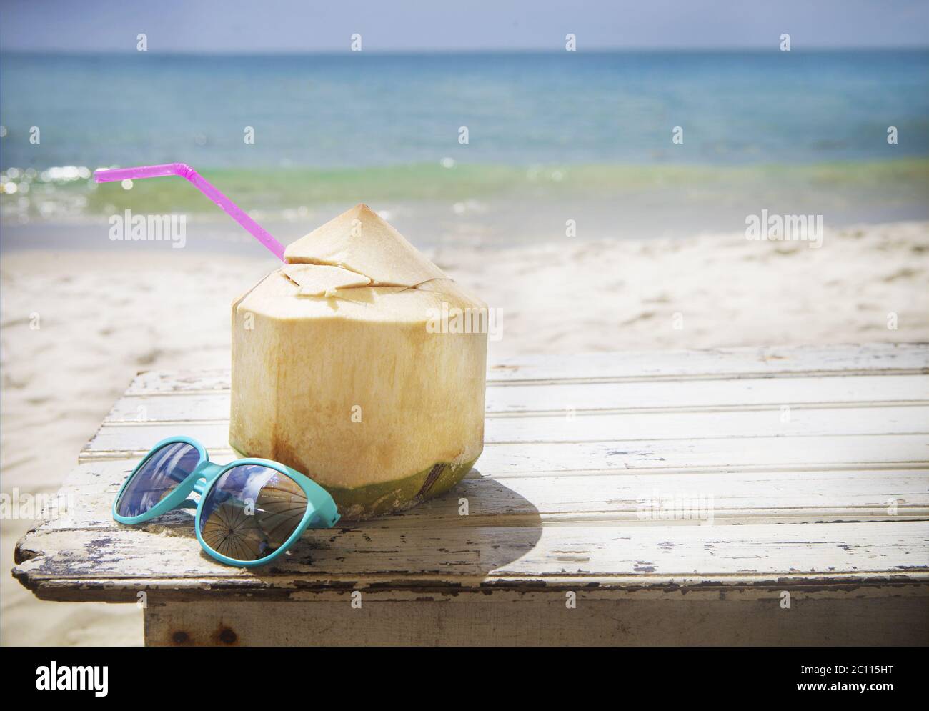 Fresh coconut cocktail and sunglasses on tropical beach Stock Photo - Alamy