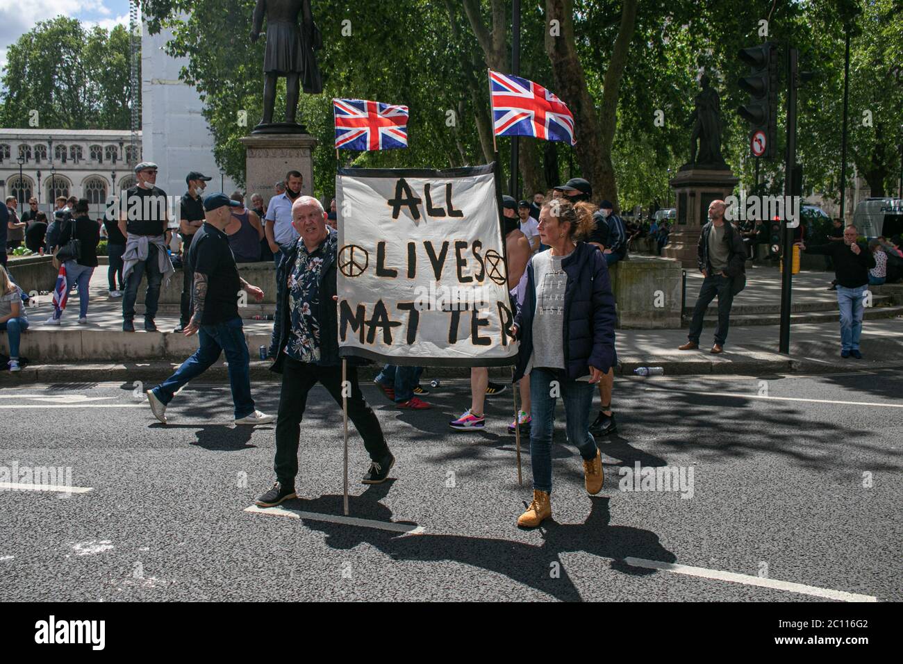 WESTMINSTER LONDON, UK. 13 June 2020. Protesters carry a banner which ...