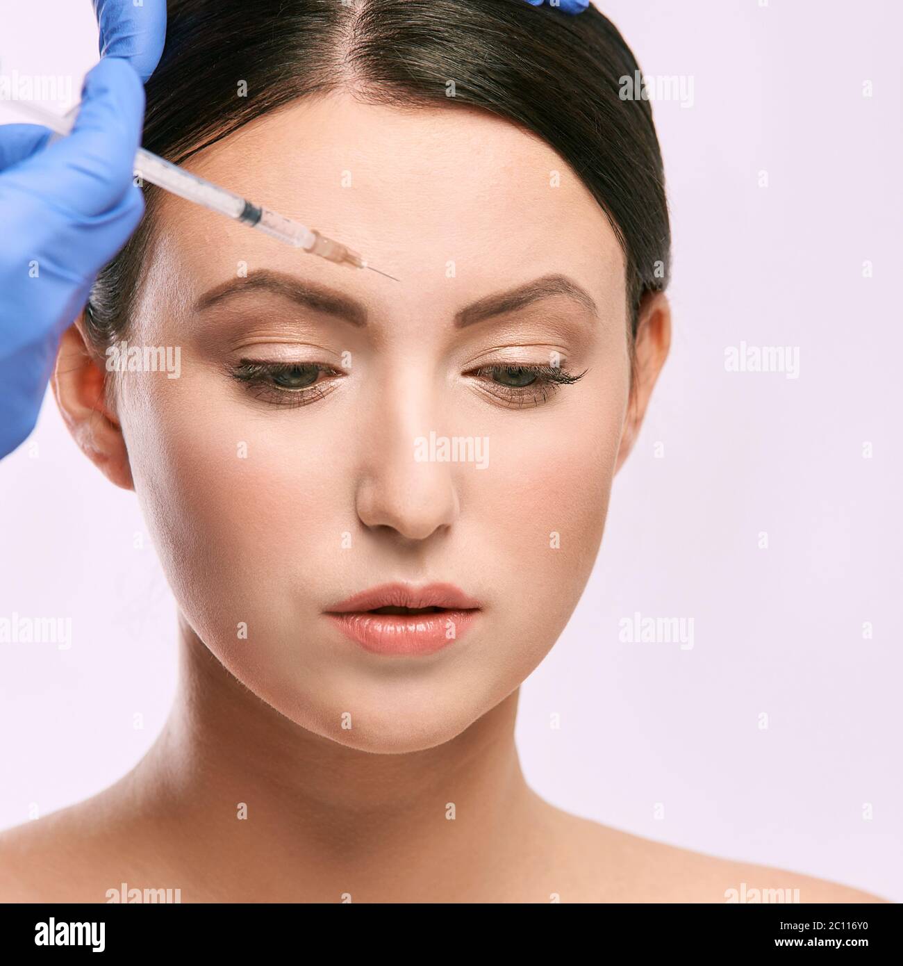 Face needle injection. Young woman cosmetology procedure. Doctor gloves ...