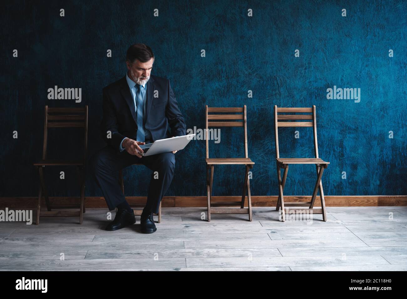 Waiting for interview. Confident mature businessman sitting on chair ...