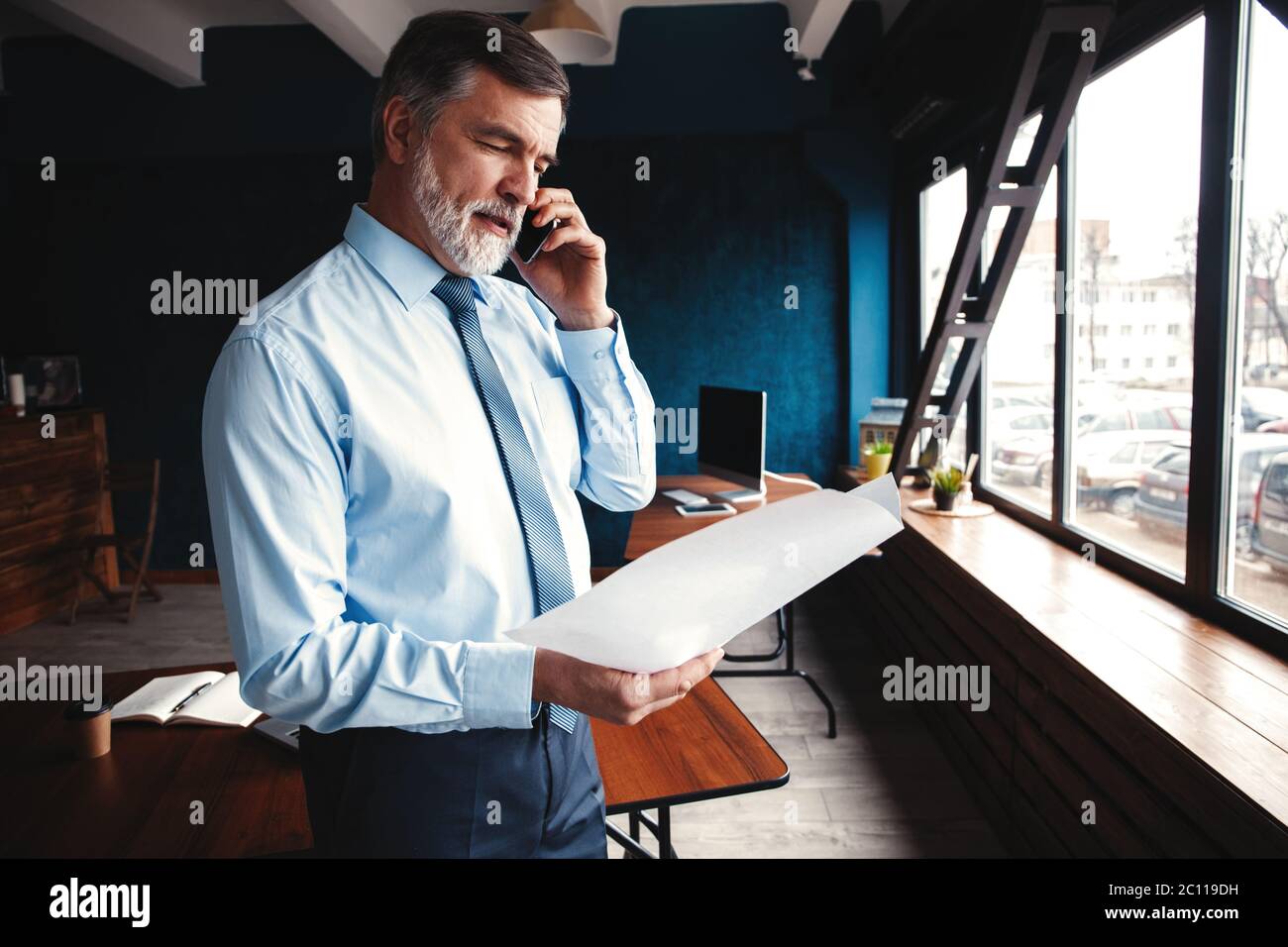 Focused concentrated accountant, mature businessman looking at the ...