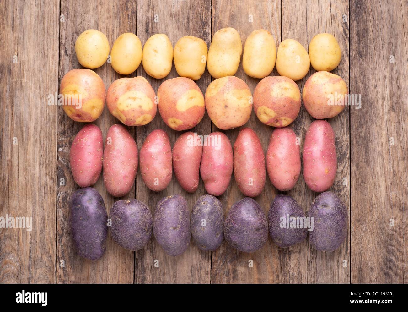 Different types of potatoes on wooden rustic table Stock Photo - Alamy