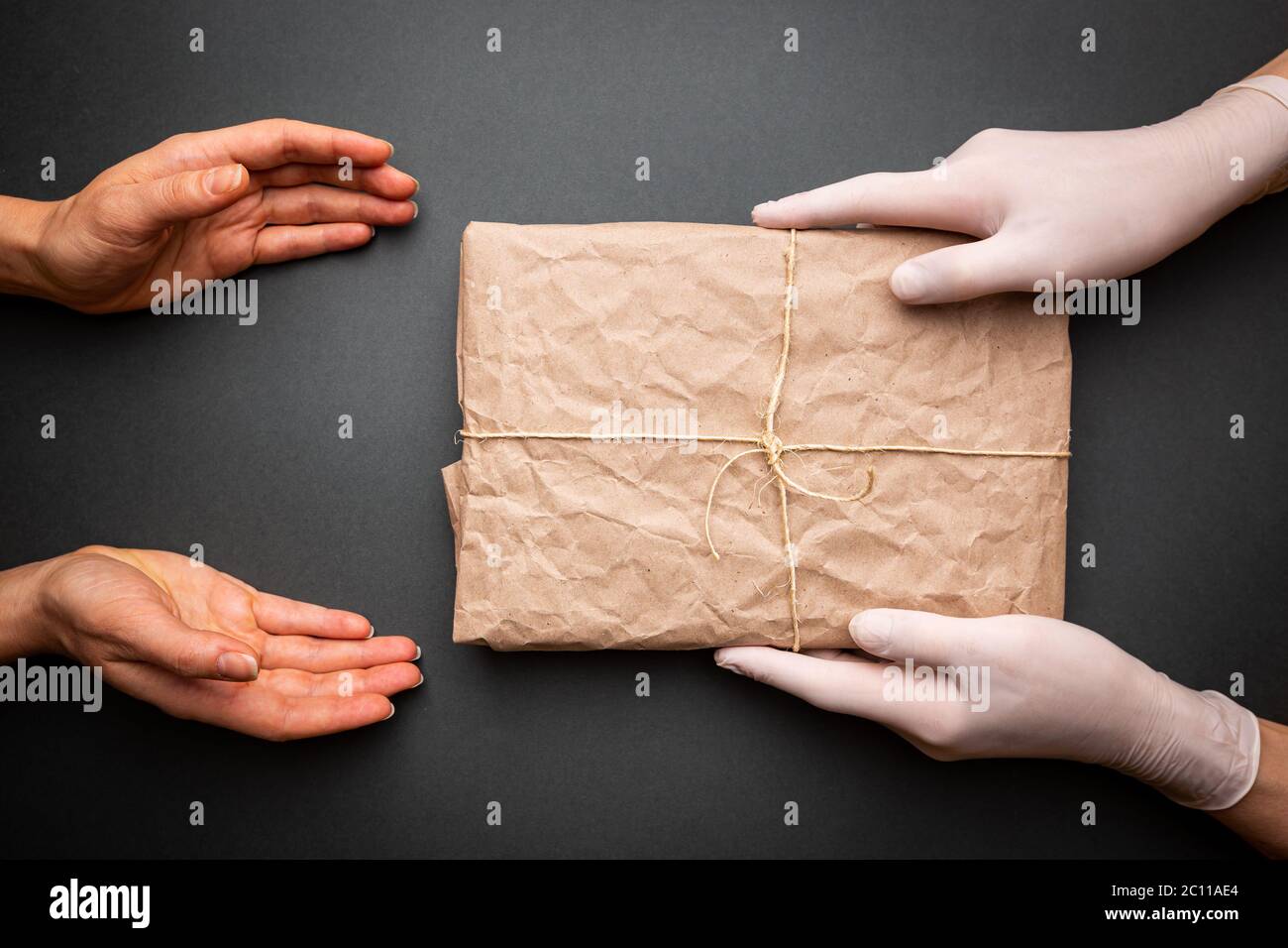 contactless delivery concept, gloved hands transmit the package with ...