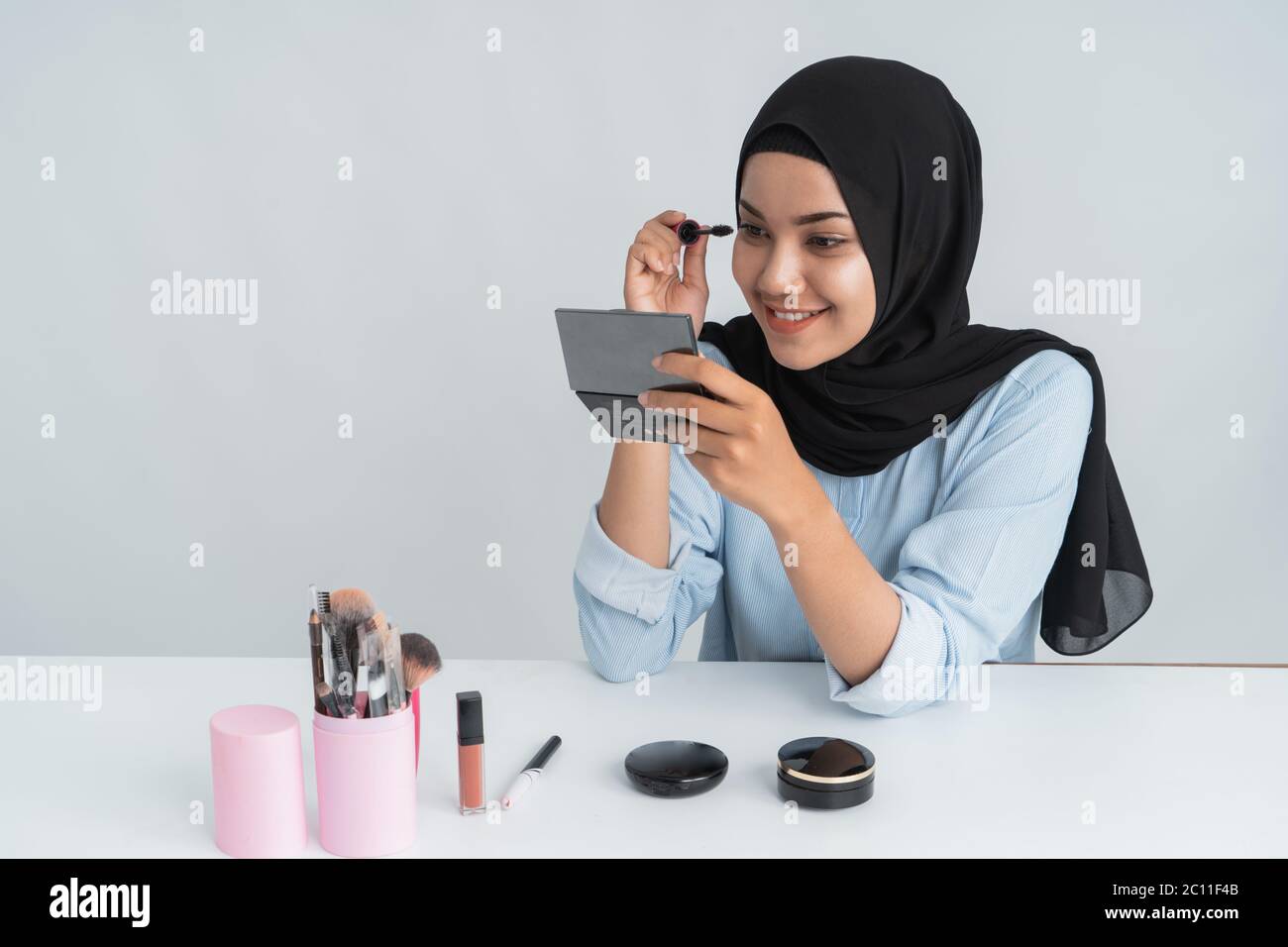 beautiful young muslim woman applying make up Stock Photo - Alamy
