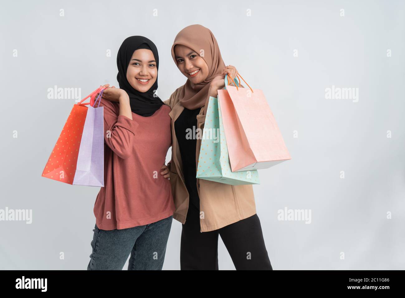two muslim best friend happy holding a shopping bag over white ...