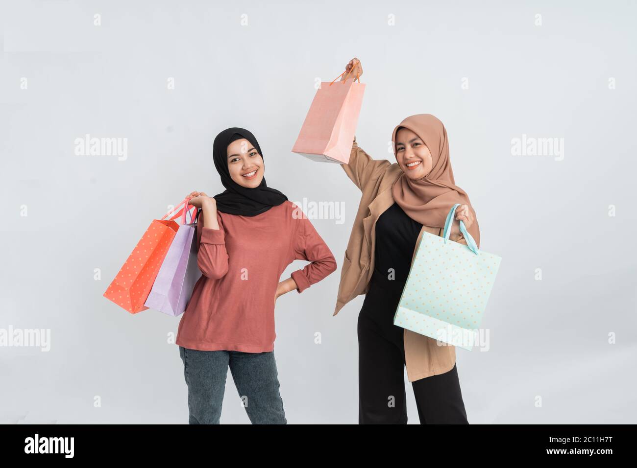 two muslim best friend happy holding a shopping bag over white ...