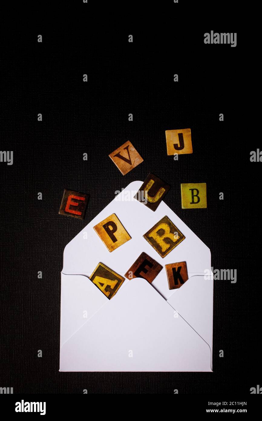 Text, message, letters scattered in white envelope isolated on black ...