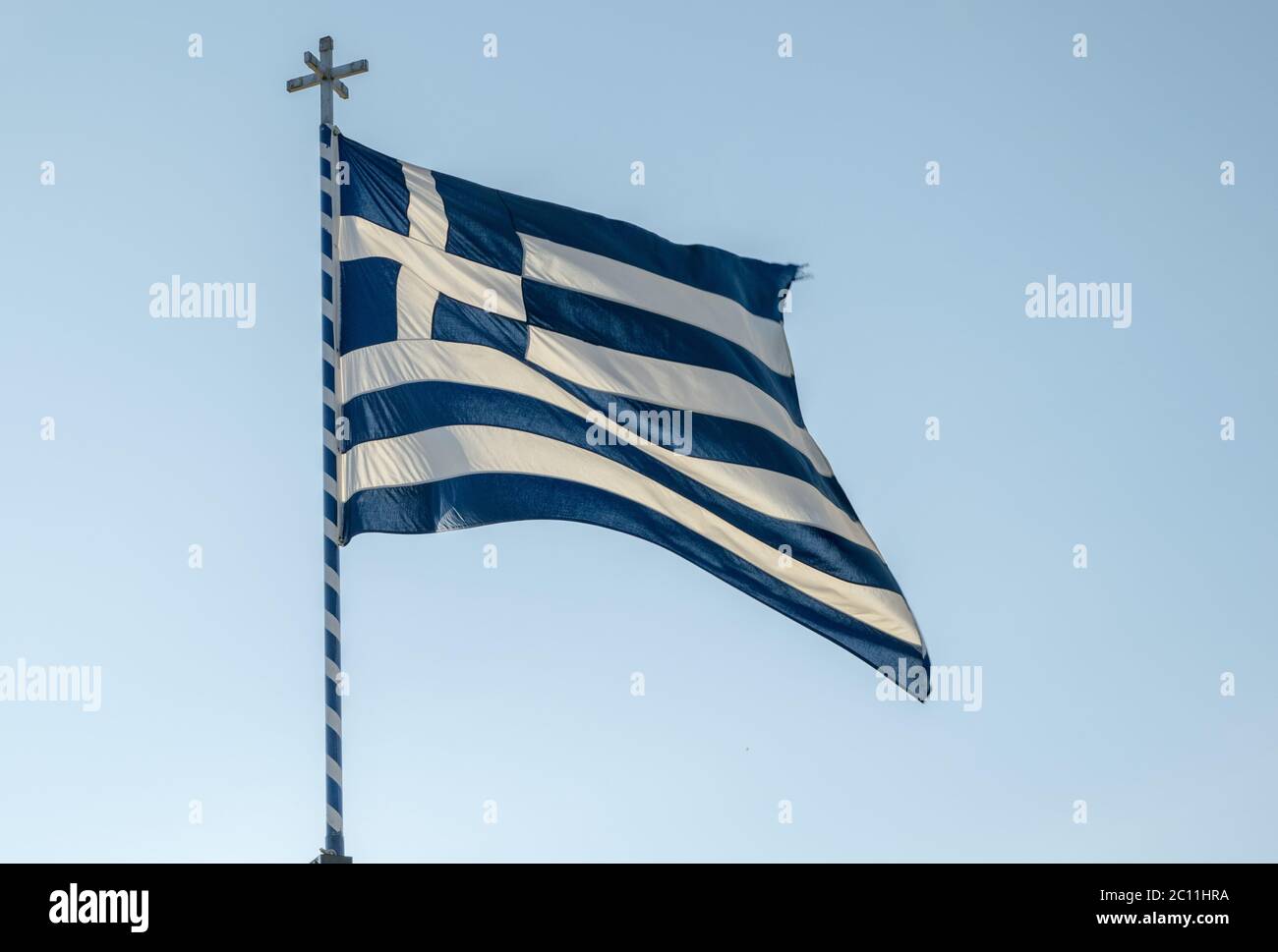 Greek flag waving on a blue and white pole with a cross at the top ...
