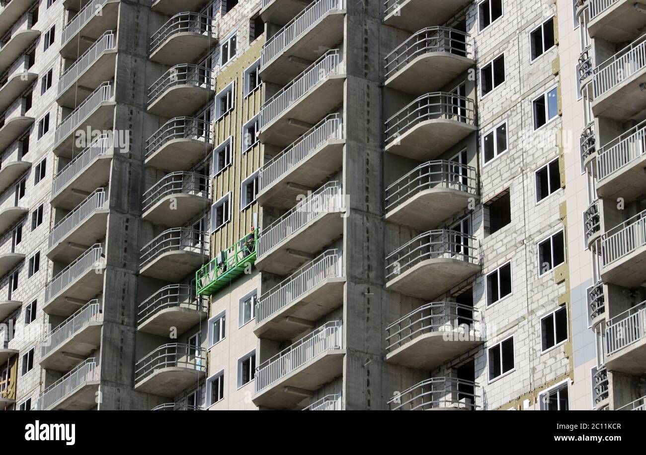 construction suspended cradle with workers on a newly built high-rise ...