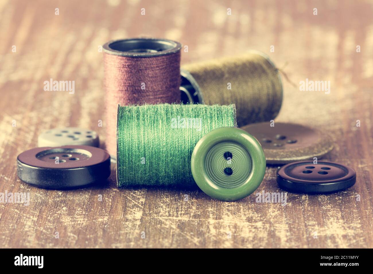 Spools of thread and buttons on wooden background Stock Photo - Alamy